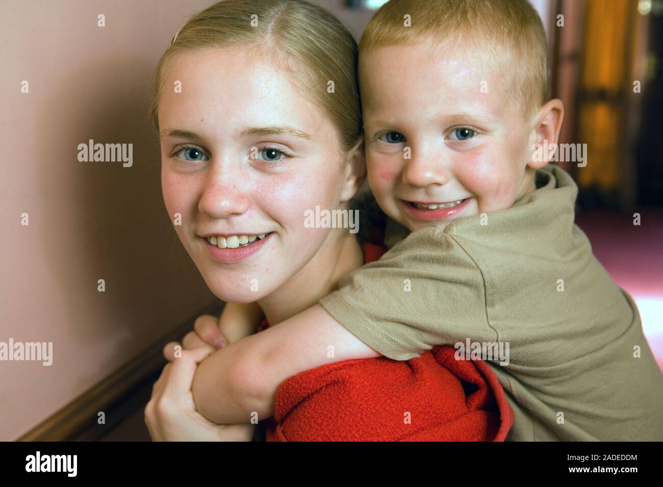 Older sister giving younger brothers a piggyback Stock Photo - Alamy