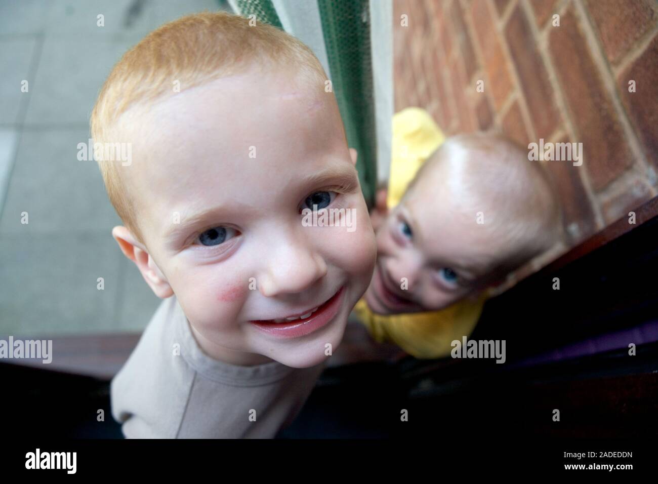Two brothers smiling up at the camera Stock Photo - Alamy
