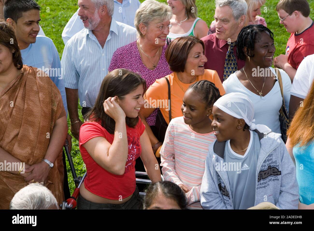 Large multiracial group of people talking and laughing with each other ...