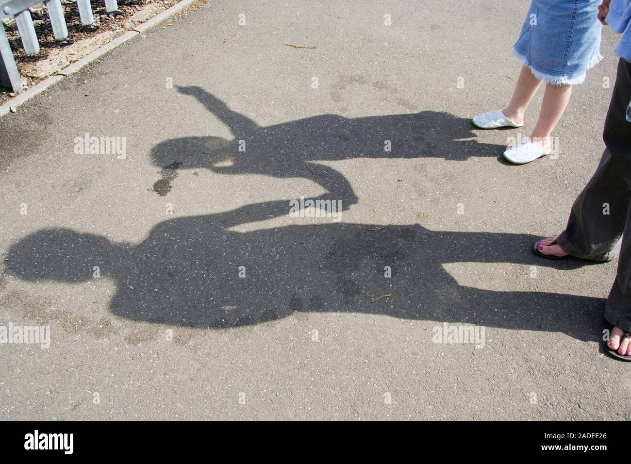 Shadow of a woman and young girl cast on a pavement Stock Photo - Alamy