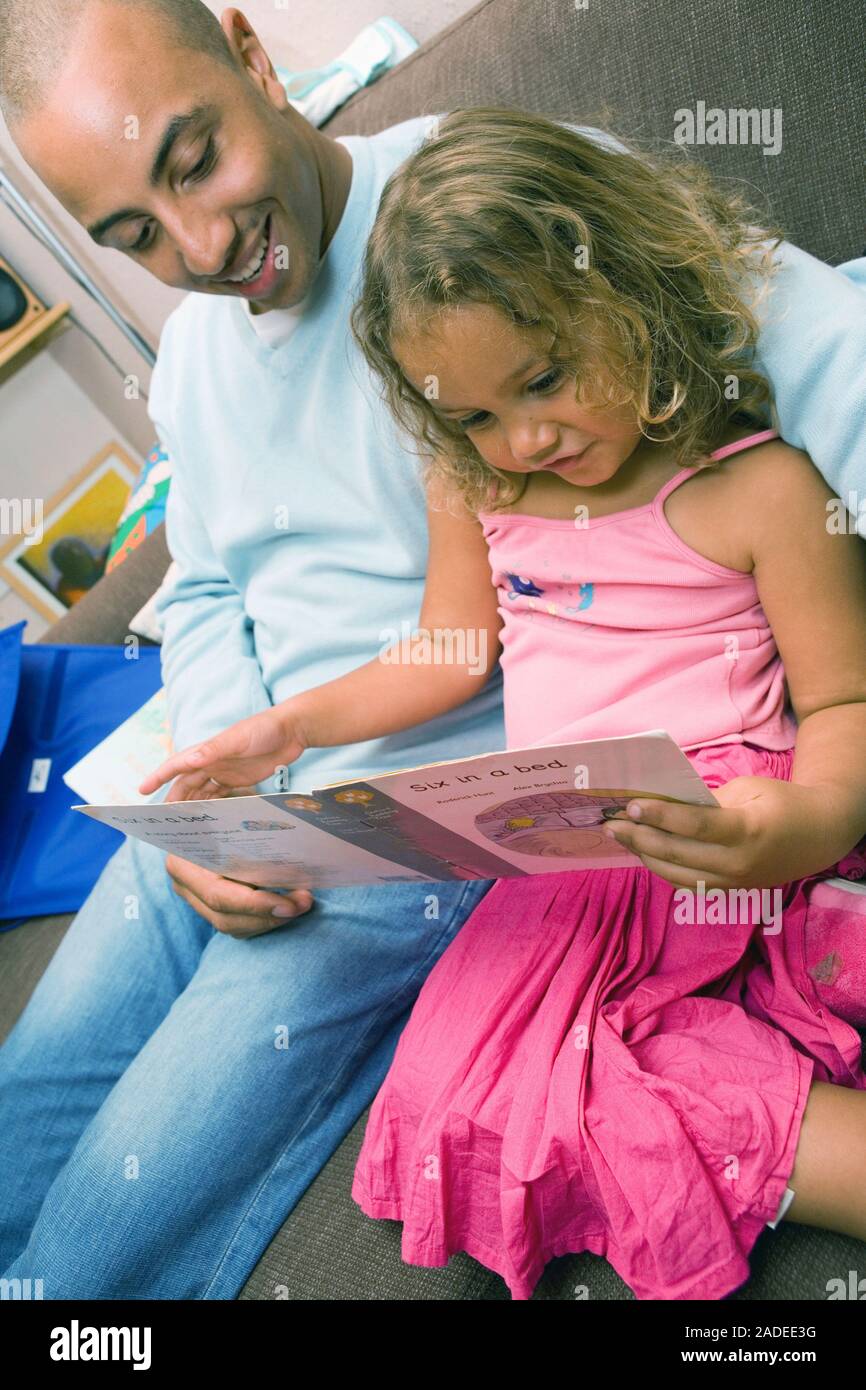 Father reading a book with his young daughter Stock Photo - Alamy