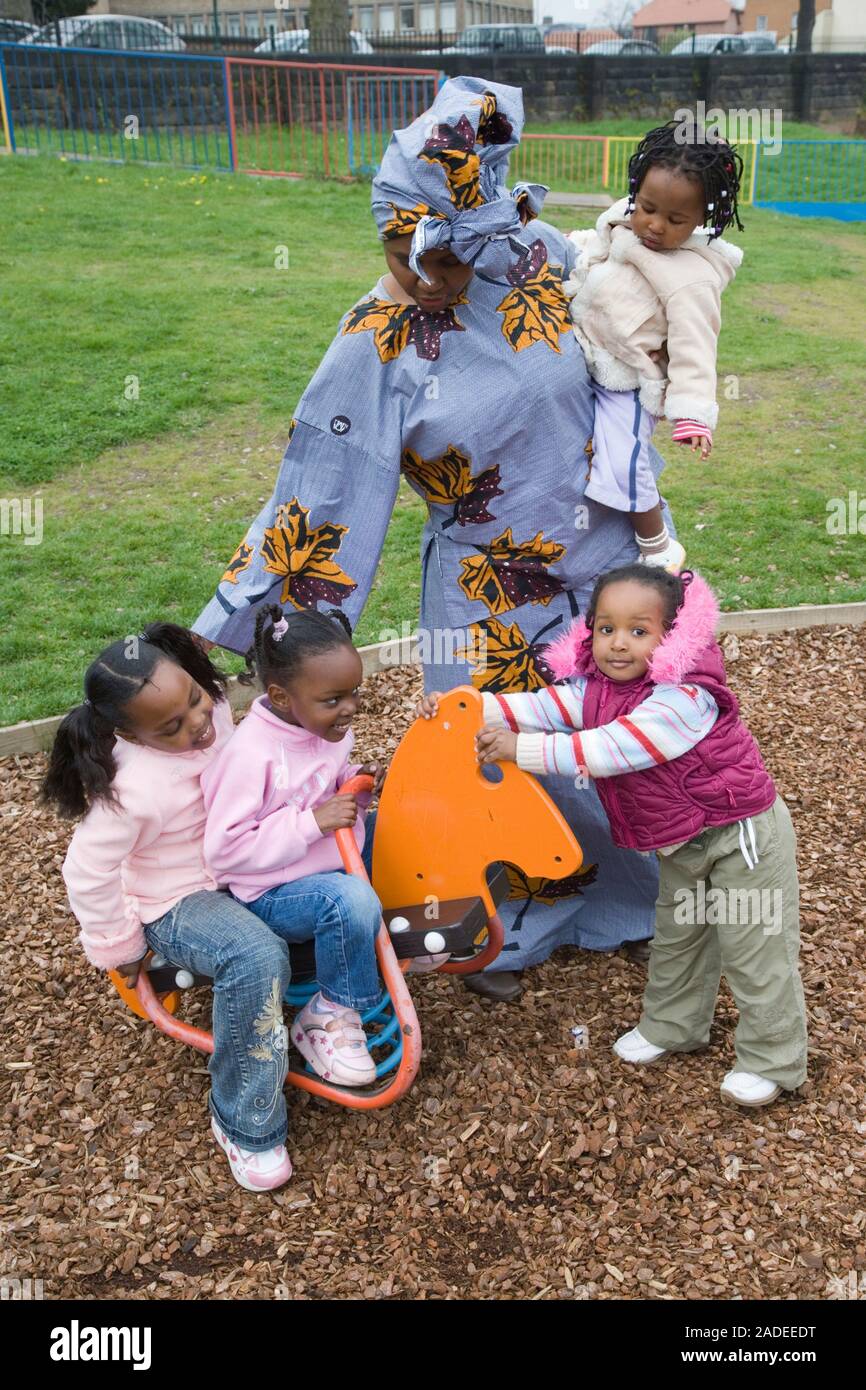 Woman playing with her four children in the playground Stock Photo - Alamy