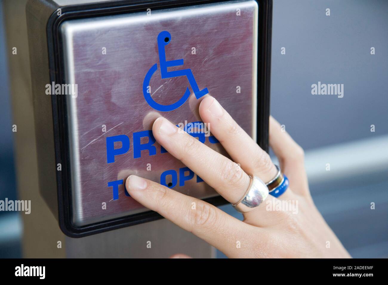 Woman's hand on a disability access door button Stock Photo - Alamy