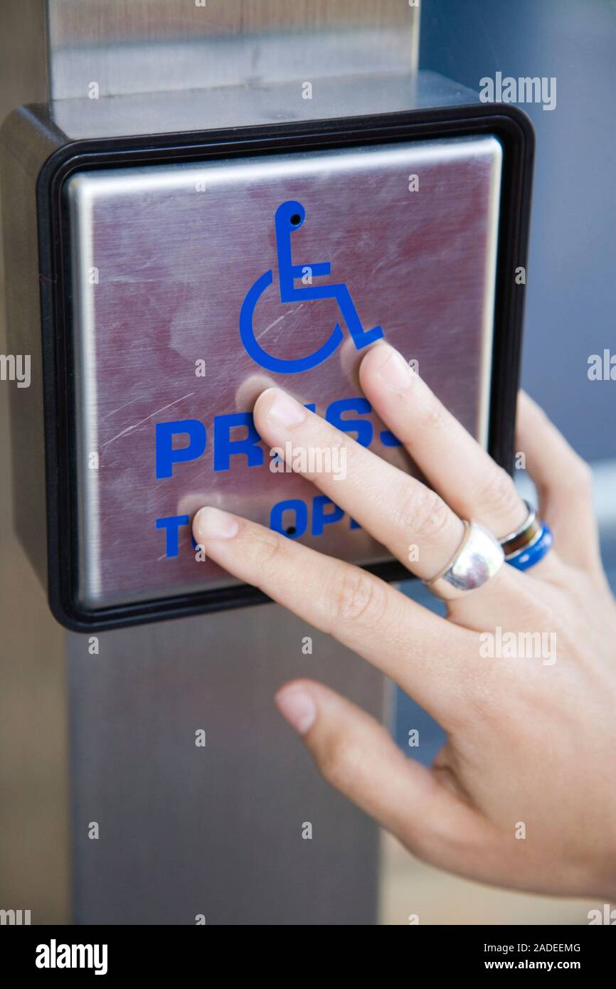 Woman's hand on a disability access door button Stock Photo - Alamy