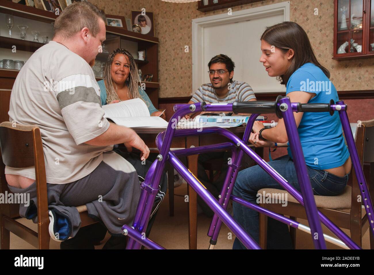 Young white student, who has cerebral palsy and uses a walking frame ...