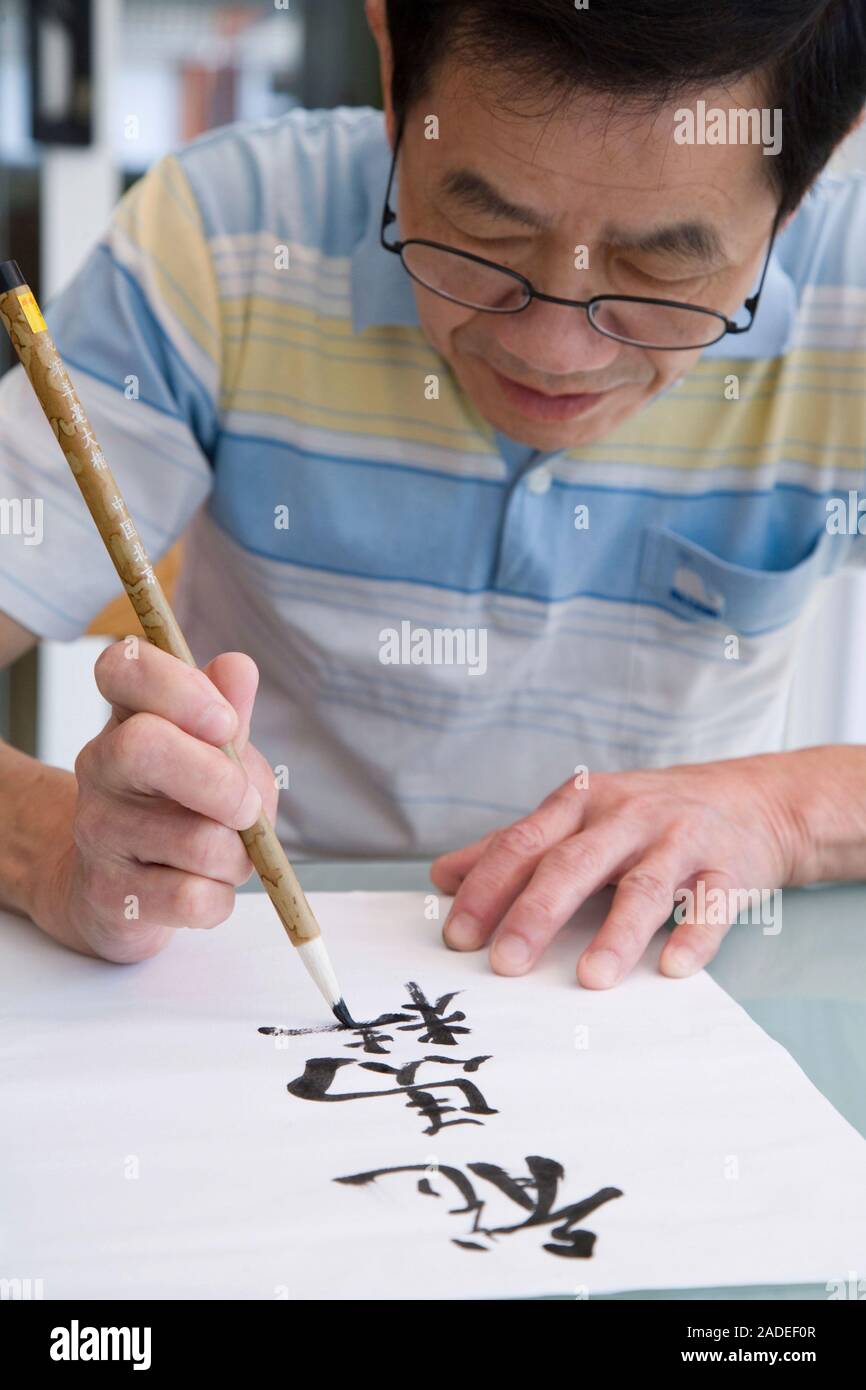 Man doing Chinese art writing using brush pen Stock Photo - Alamy