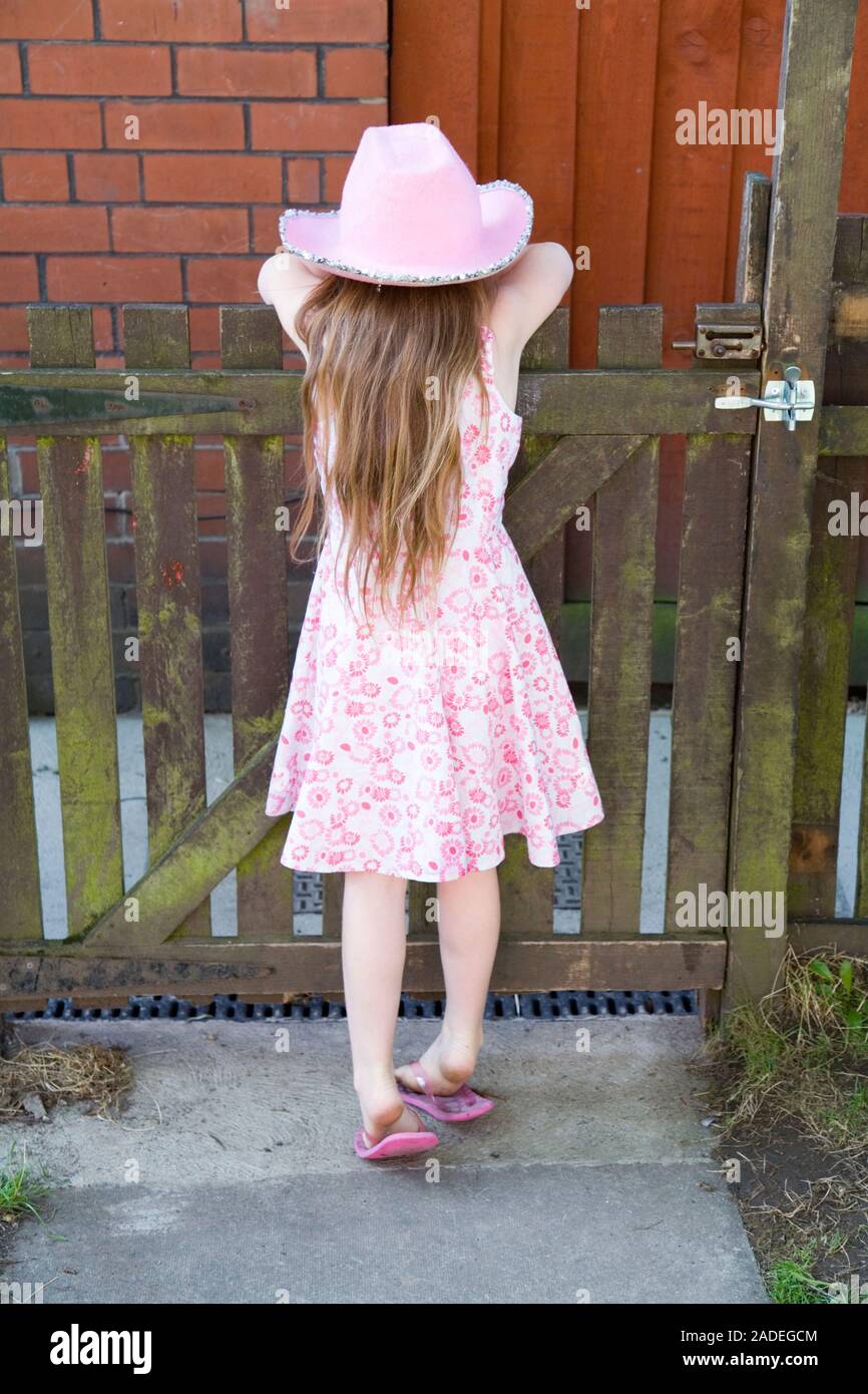 Little girl leaning over a garden gate Stock Photo - Alamy