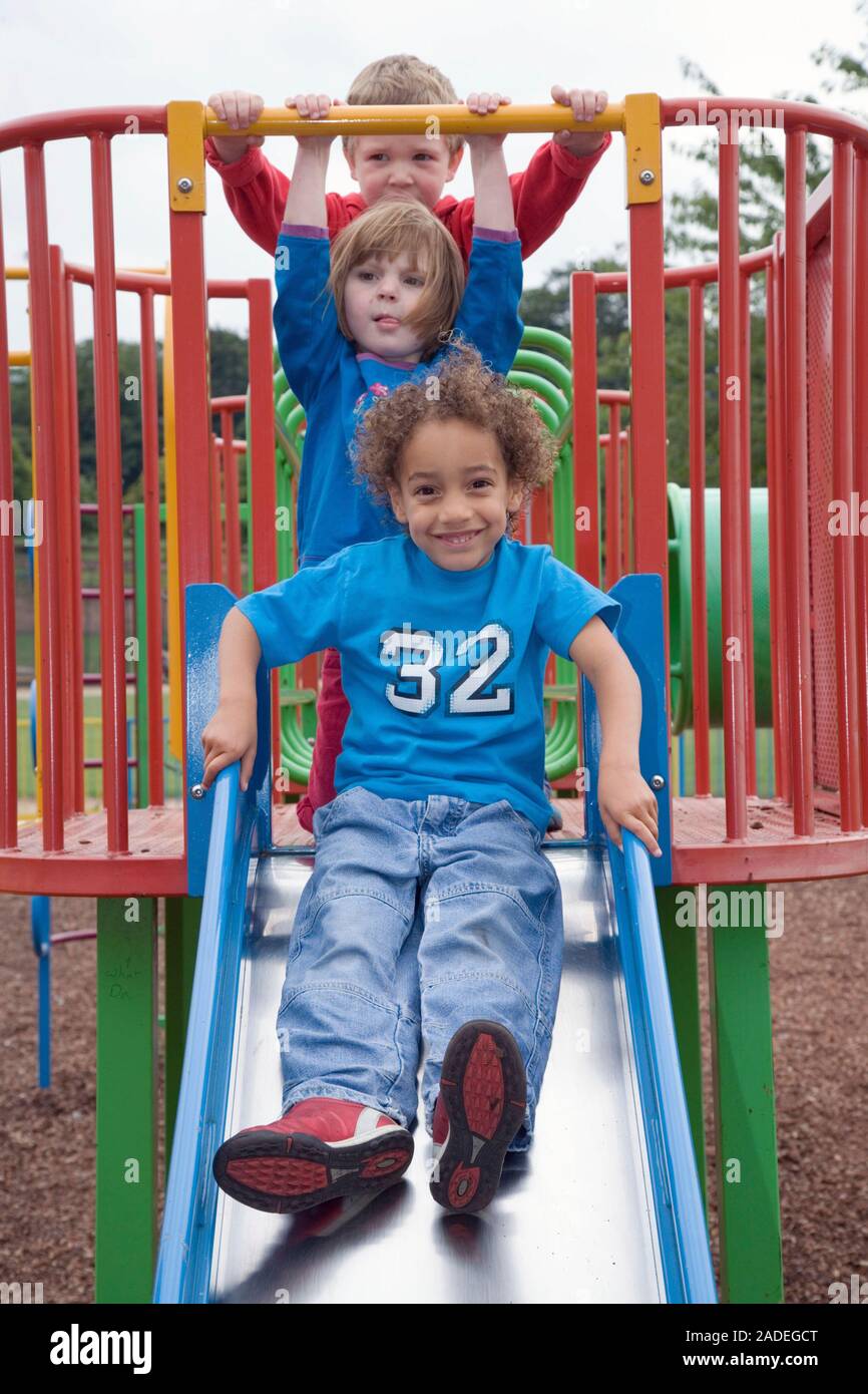 Little children playing on a slide Stock Photo - Alamy