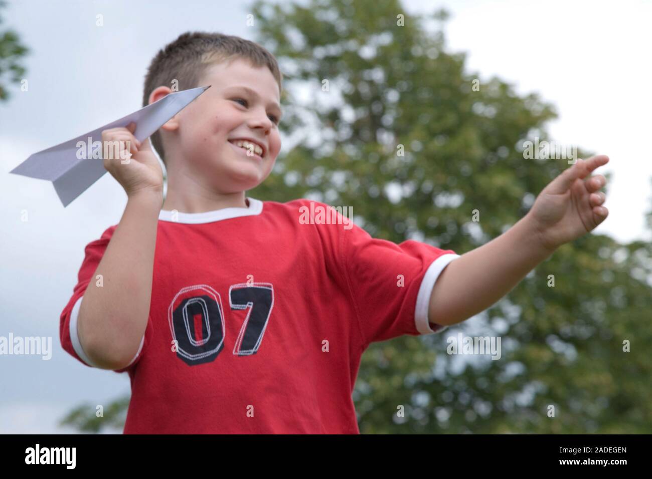 Boy flying a paper airplane Stock Photo - Alamy