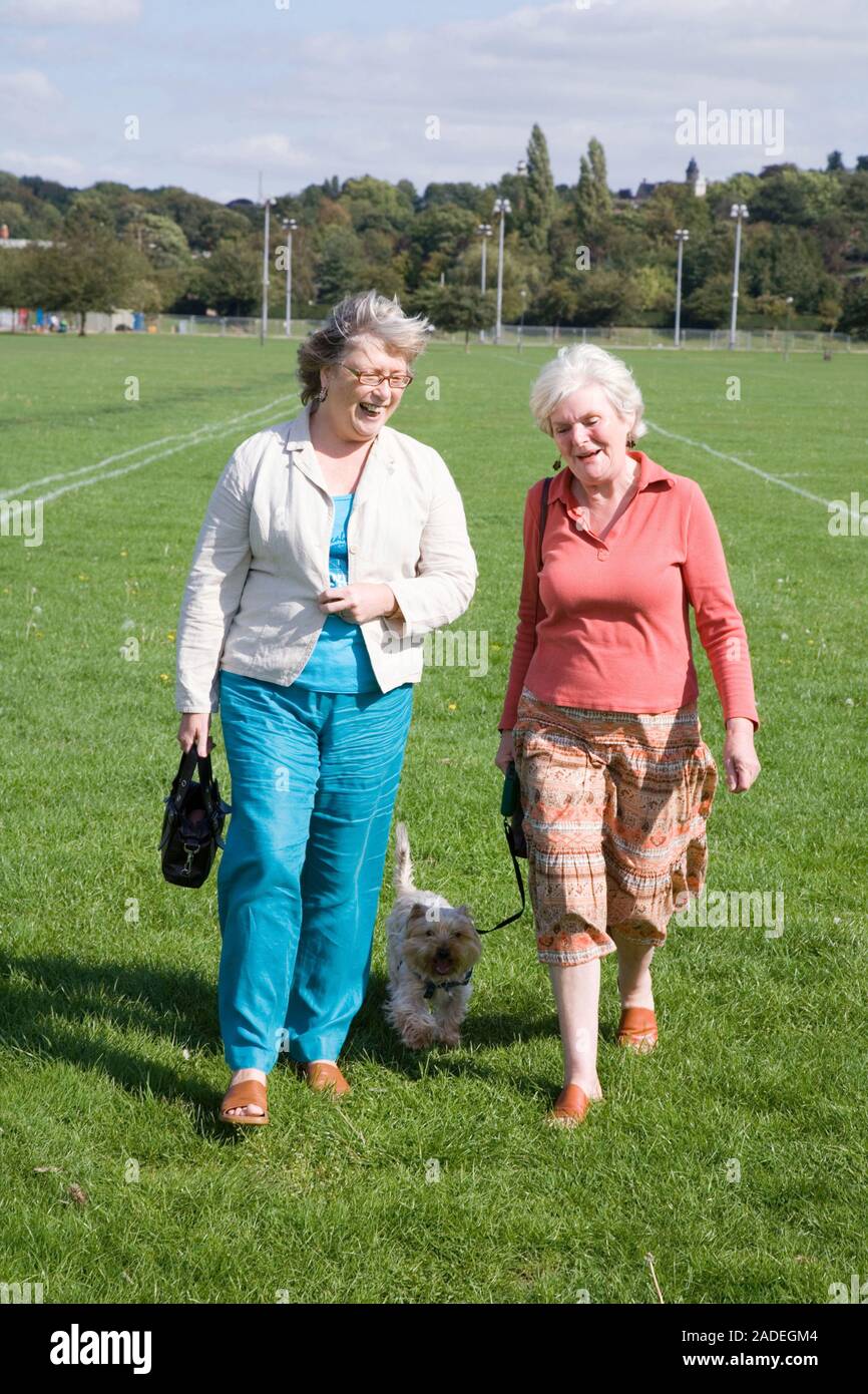 Women walking a dog in the park Stock Photo - Alamy