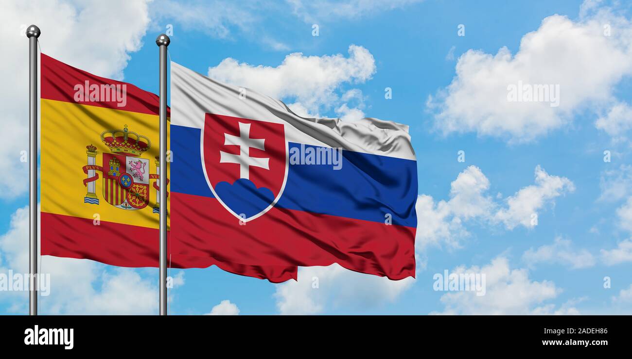 Spain and Slovakia flag waving in the wind against white cloudy blue ...
