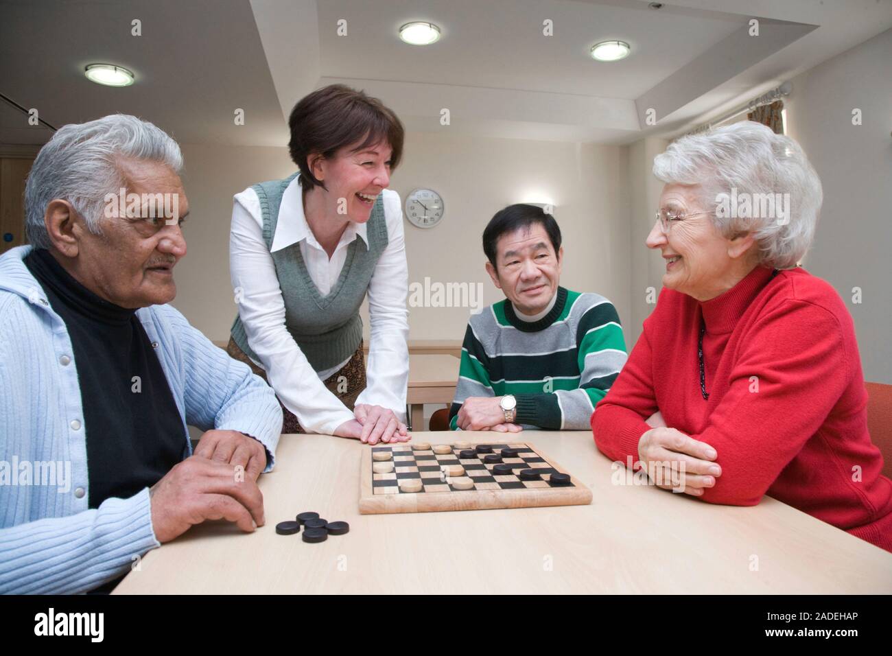 Group of older people playing draughts in a care home Stock Photo - Alamy