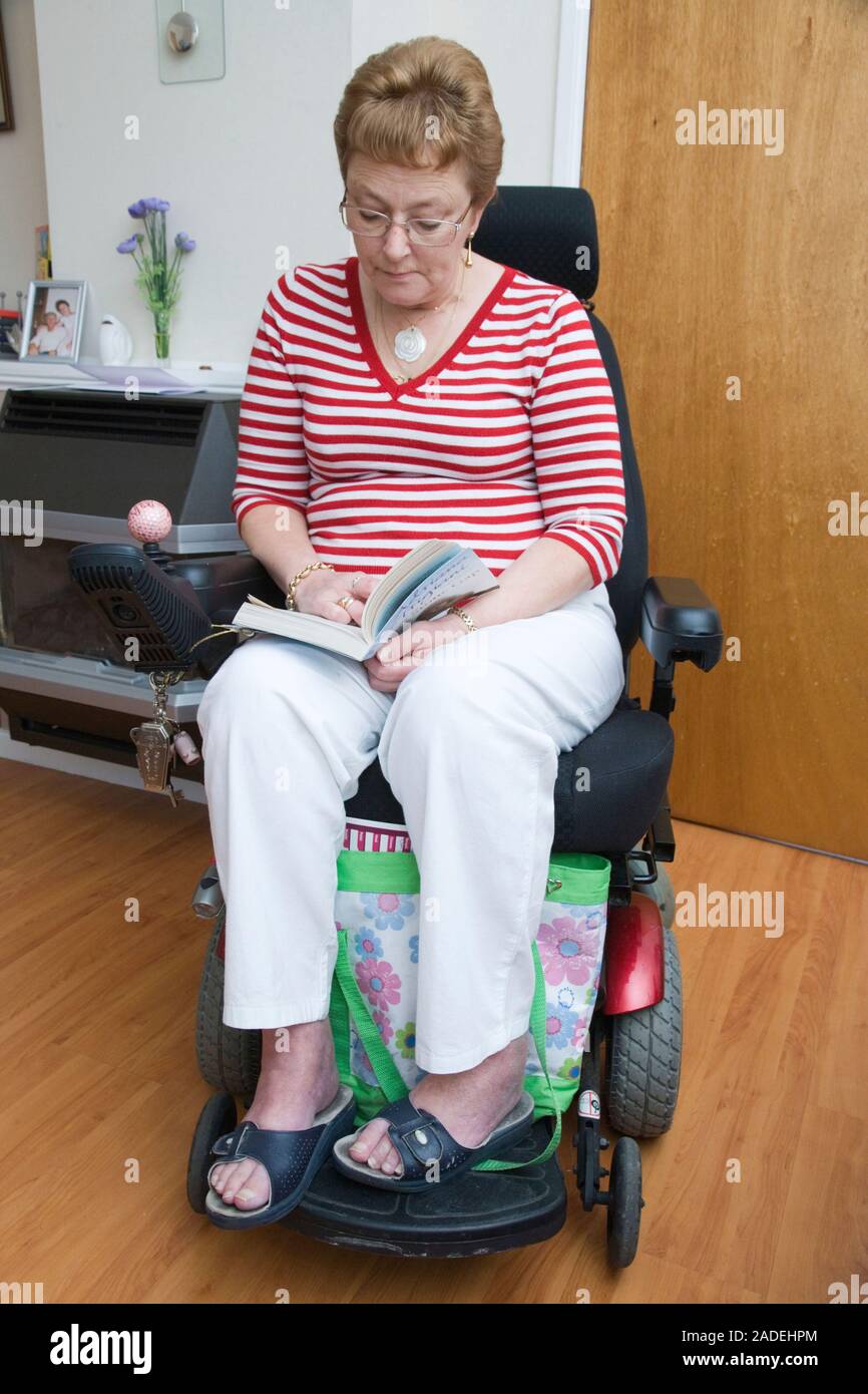 Older woman wheelchair user reading a book Stock Photo - Alamy