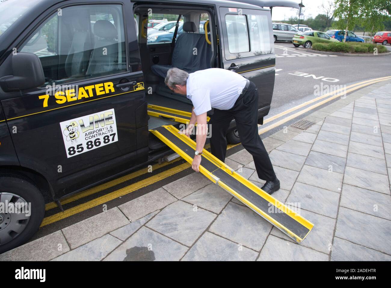 Taxi driver putting a disabled ramp on his taxi Stock Photo - Alamy