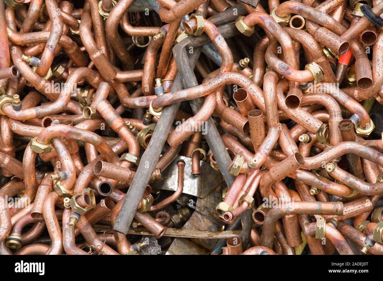 Pile of copper piping waiting to be sorted at a metal recycling centre ...