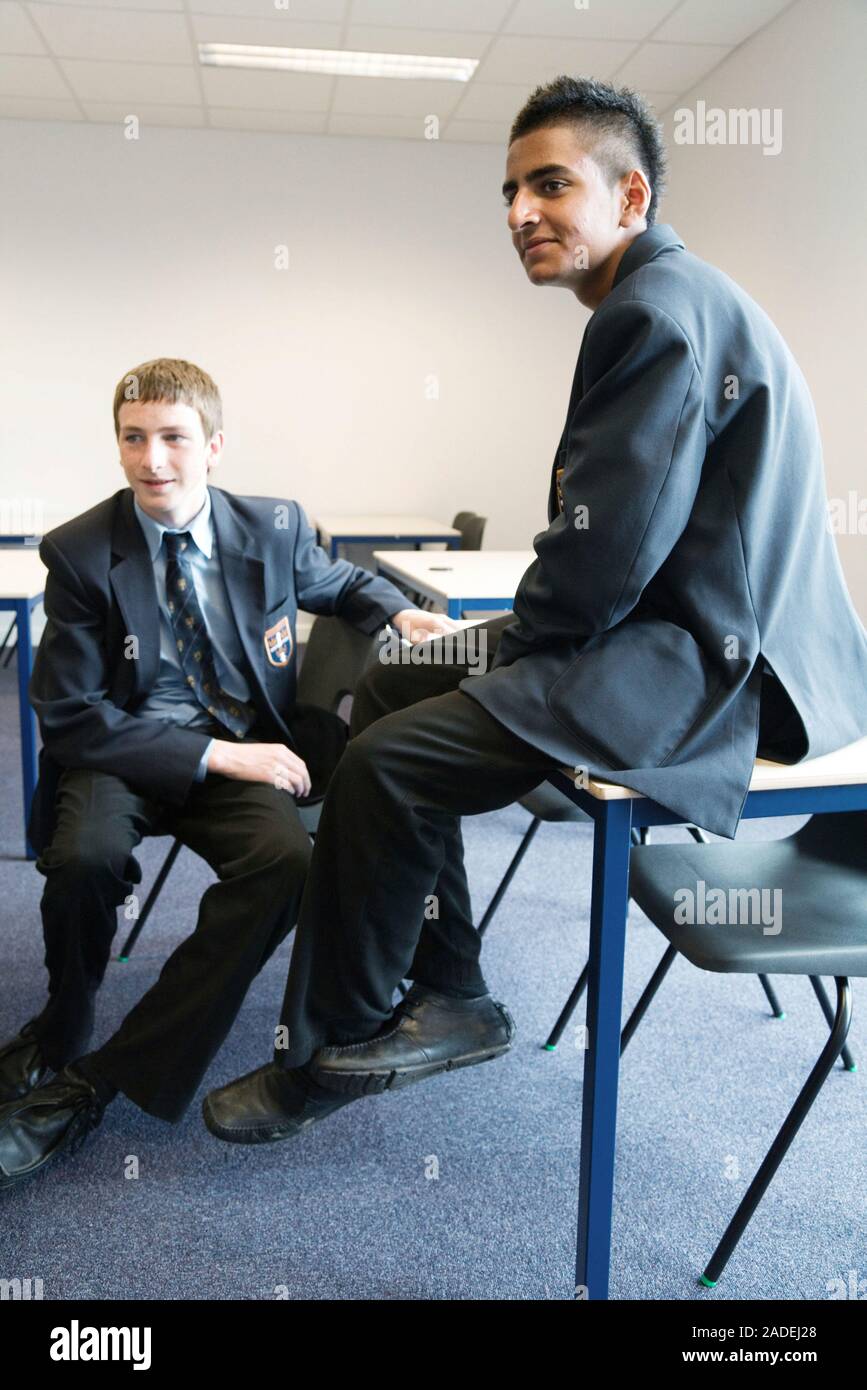 Secondary school students taking time out to chat in a classroom Stock ...