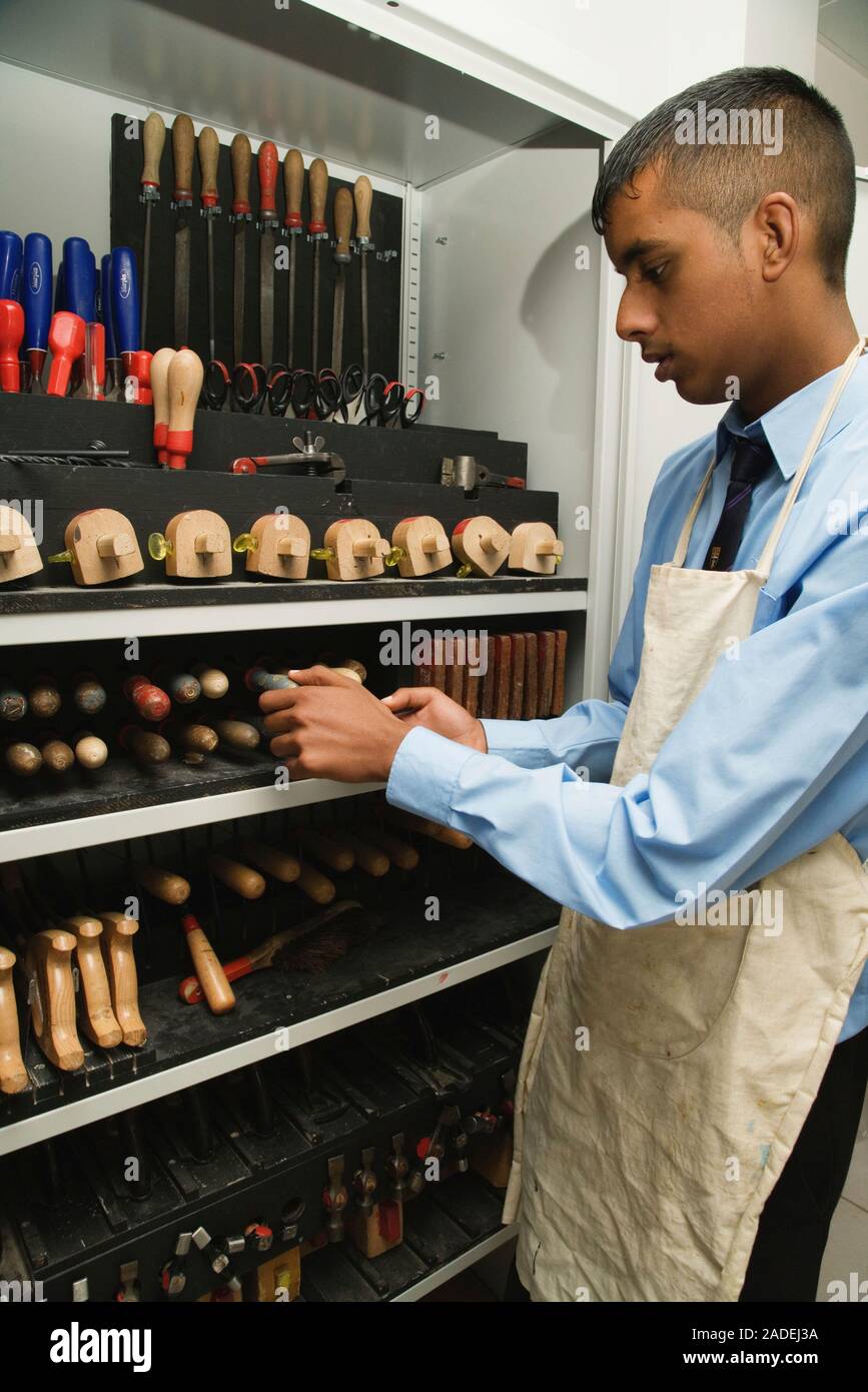 Secondary school student selecting tools to use in a woodwork lesson ...