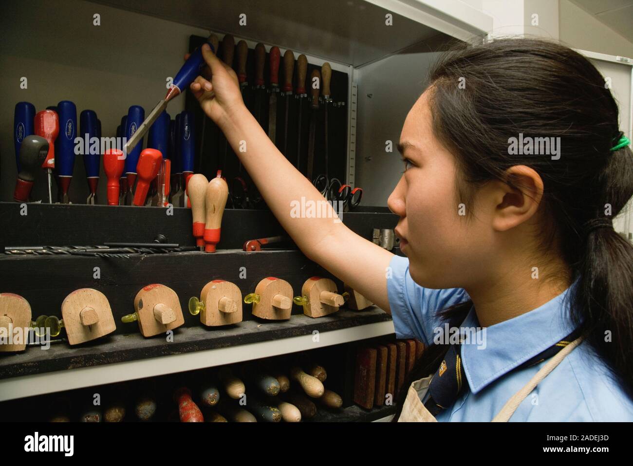 Secondary school student selecting tools to use in a woodwork lesson ...