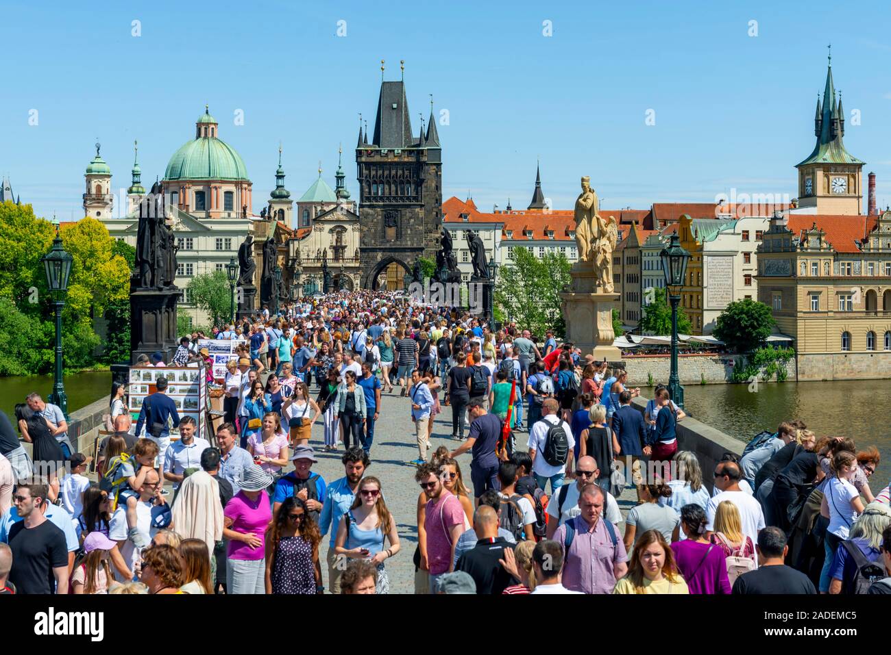 Crowd on the Charles Bridge, Karluv most, in the back dome of the Church of the Holy Cross with ...