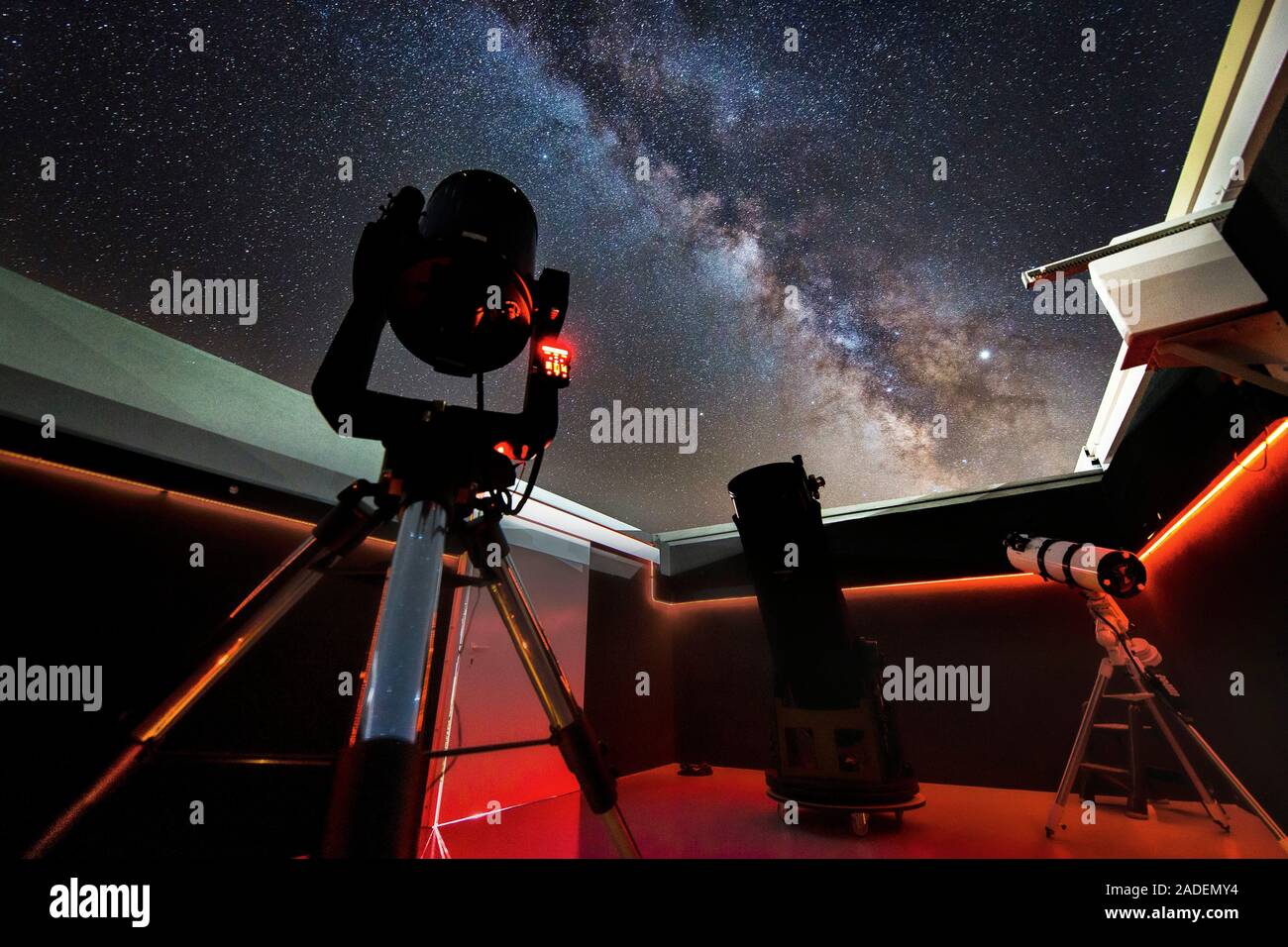 Telescopes at an observatory with the Milky Way in the night sky seen ...
