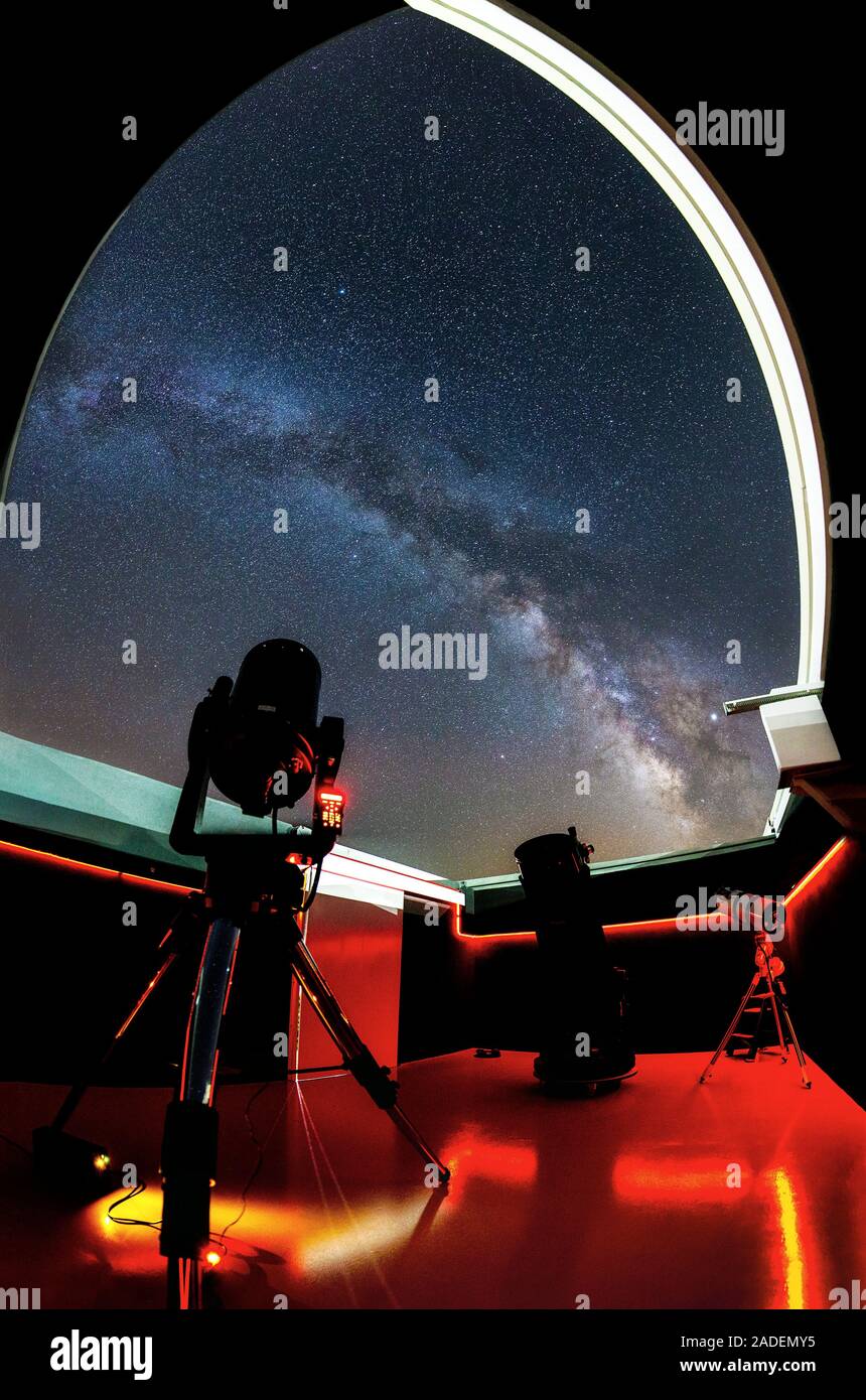 Telescopes at an observatory with the Milky Way in the night sky seen ...