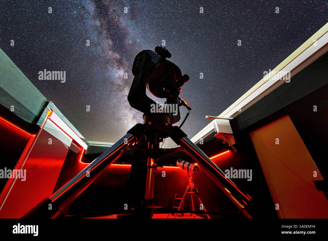 Telescopes at an observatory with the Milky Way in the night sky seen ...