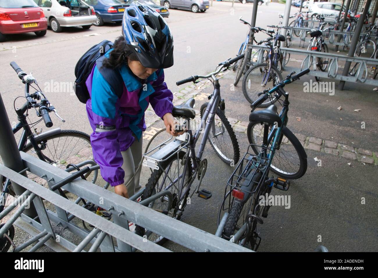 Woman locking up her bike in a works bike shed Stock Photo - Alamy