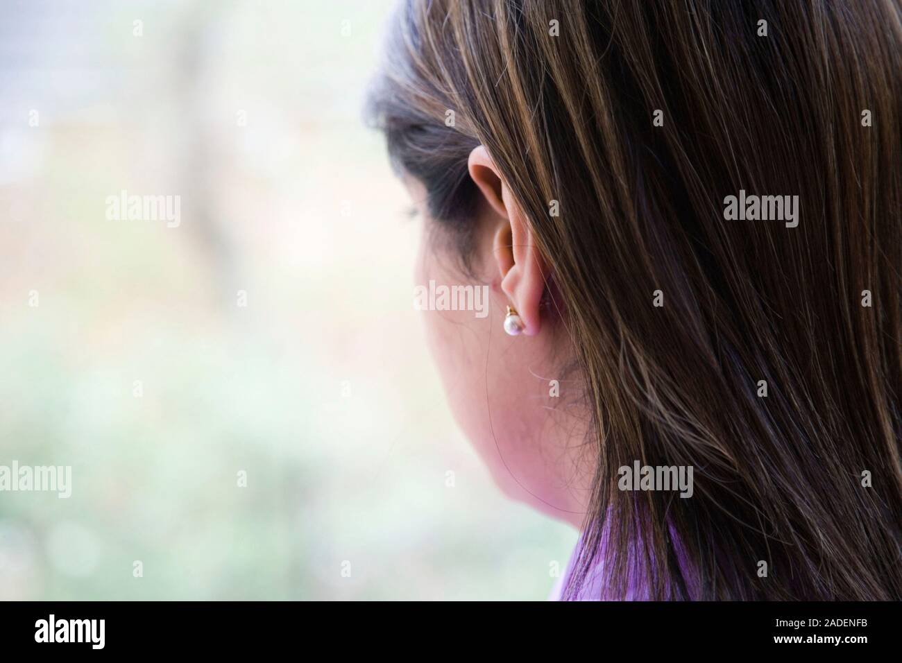 Woman staring out of a window Stock Photo - Alamy