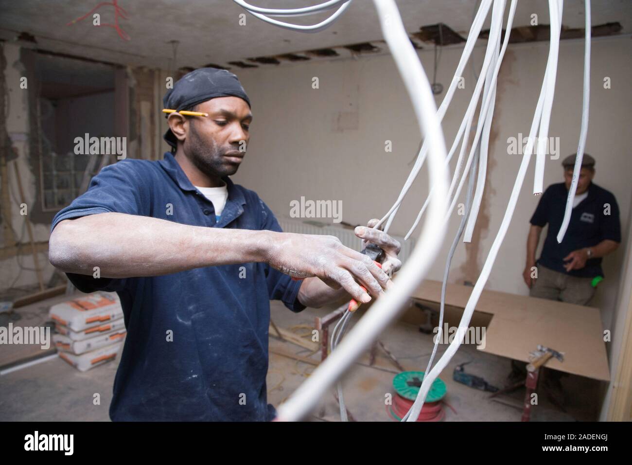 Electrician installing cables Stock Photo - Alamy