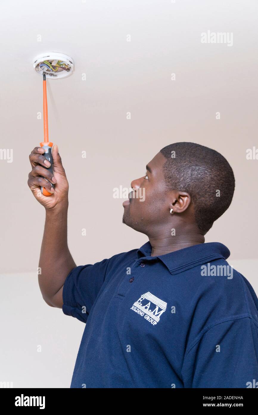 Electrician fixing a smoke detector into the ceiling Stock Photo - Alamy