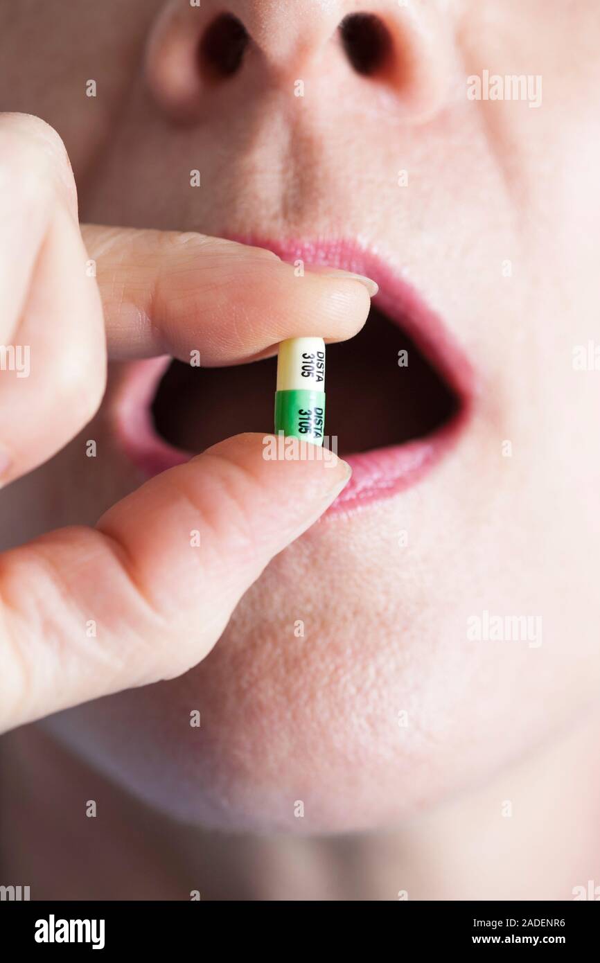 Woman holding a capsule of the drug Prozac in her mouth. Prozac ...
