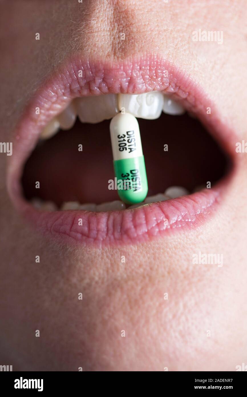 Woman holding a capsule of the drug Prozac in her mouth. Prozac ...