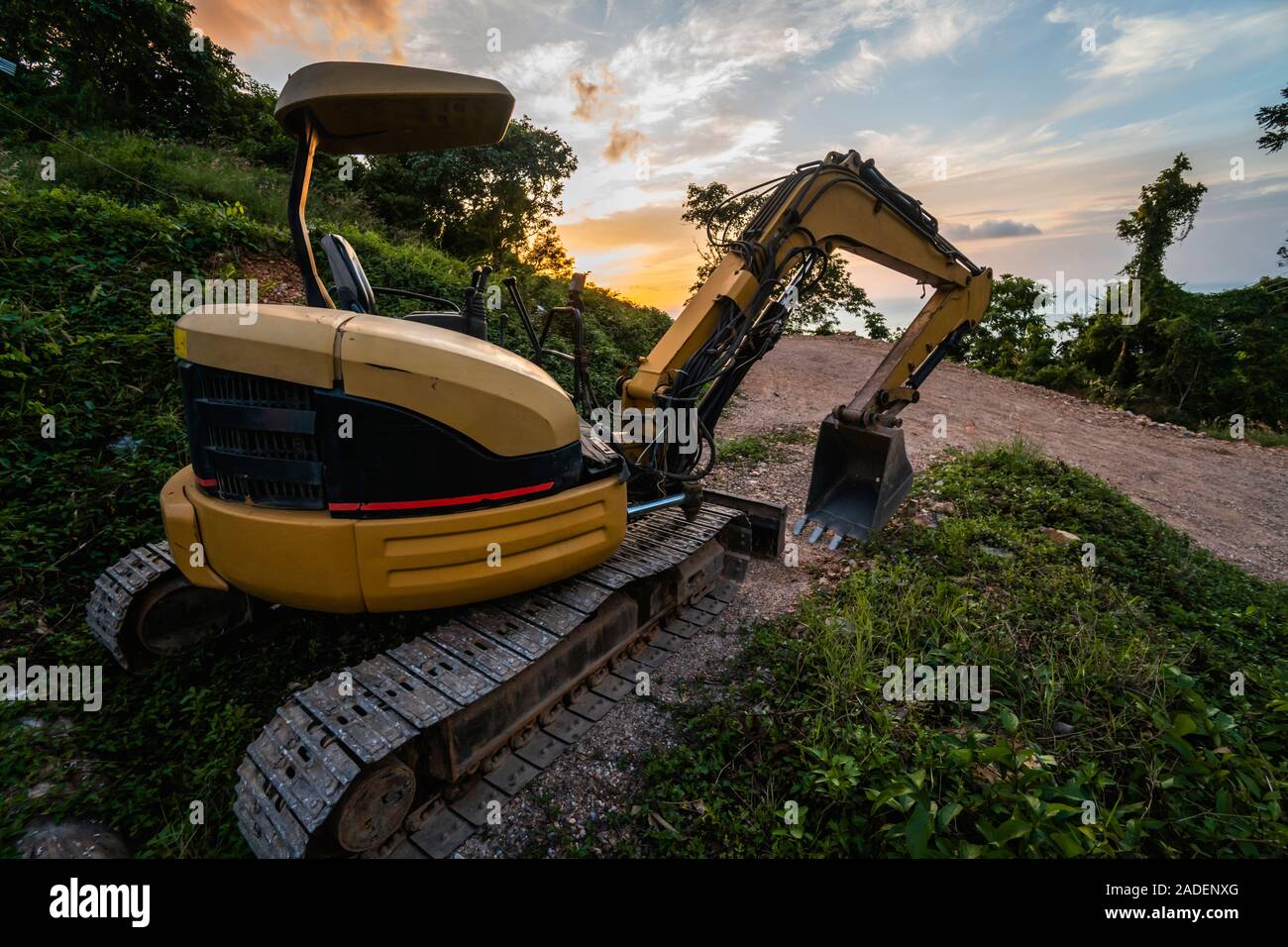 The modern excavator on the construction site with sunset sky. Large ...