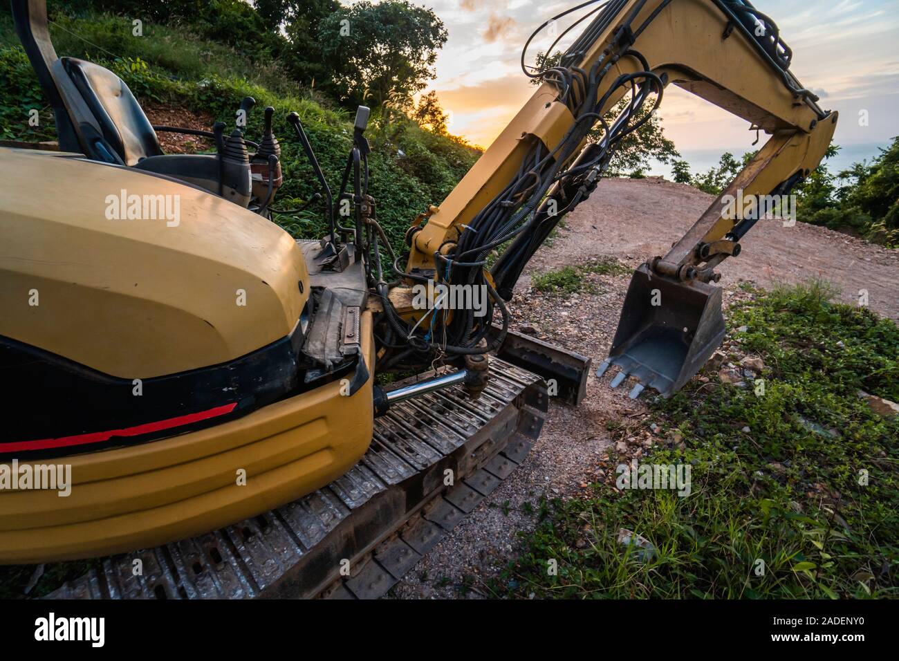 The modern excavator on the construction site with sunset sky. Large ...