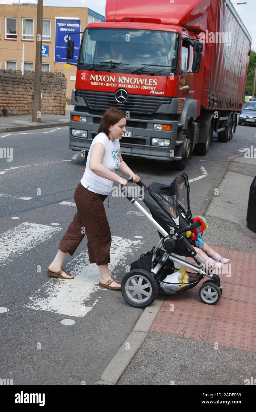 Mother crossing road with baby Stock Photo - Alamy