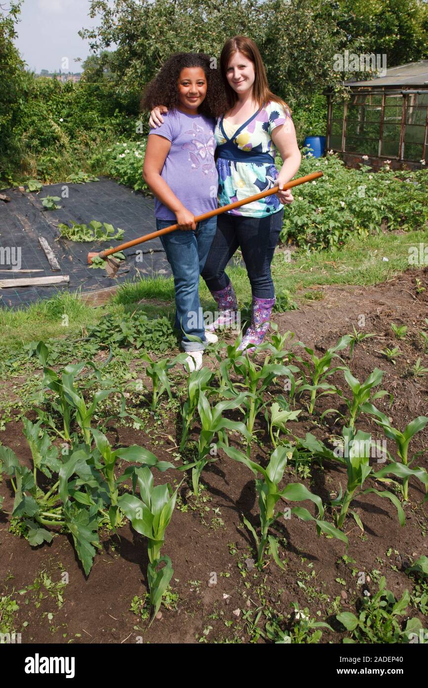 Woman and girl with hoe by sweetcorn patch Stock Photo - Alamy