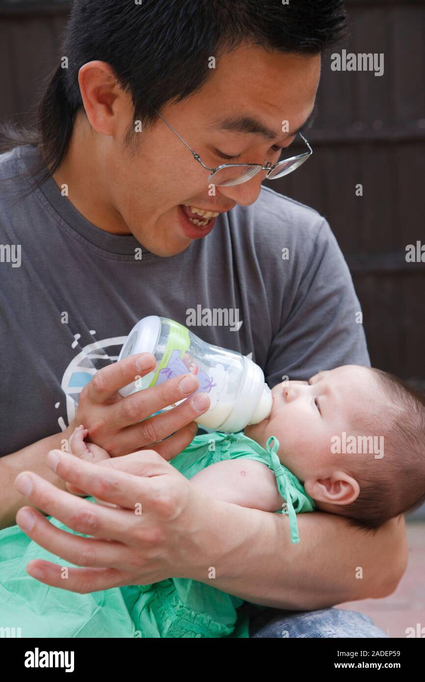 Chinese father feeding his baby daughter Stock Photo - Alamy