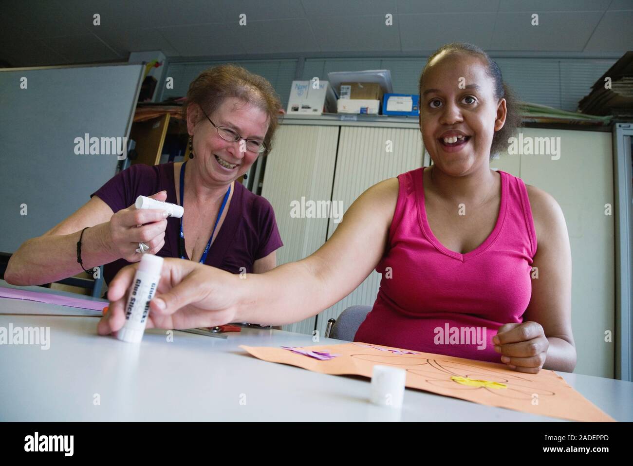 Teacher helping student with learning disability in art class Stock ...