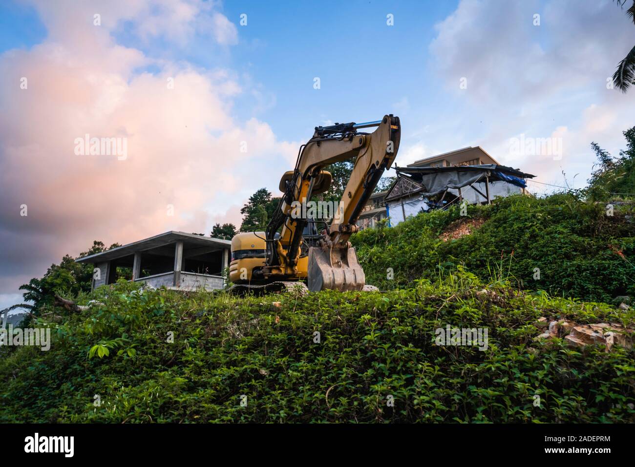 The modern excavator on the construction site with sunset sky. Large ...