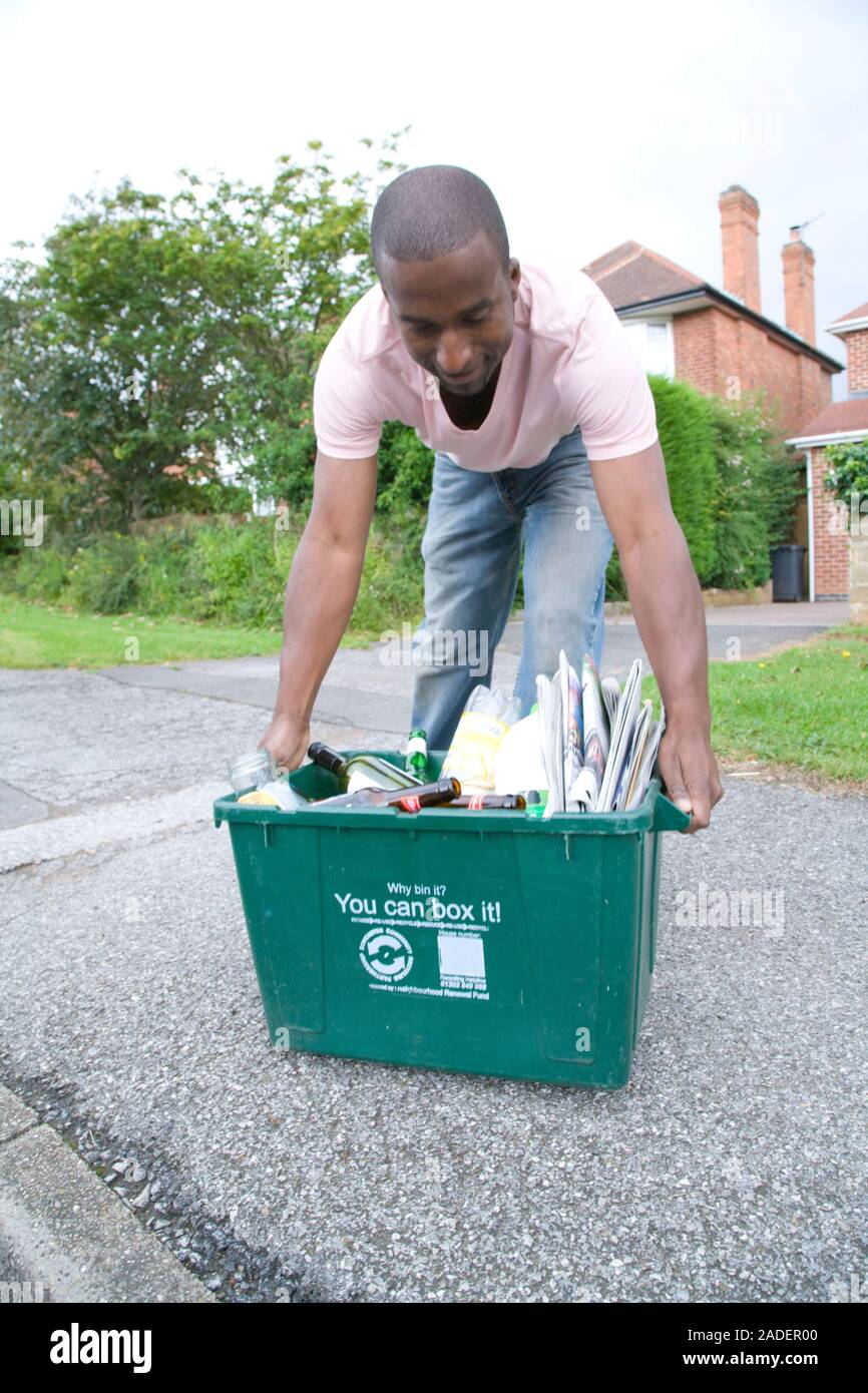 Man placing curb side recycling collection box on the pavement ready ...