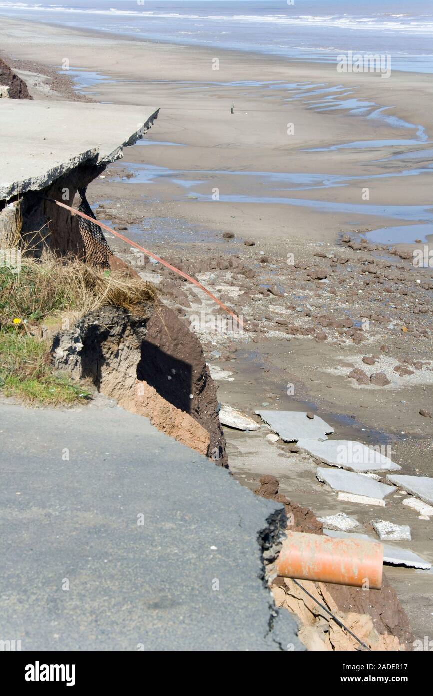 Concrete flooring and roadway abruptly ending at eroded cliff edge at ...