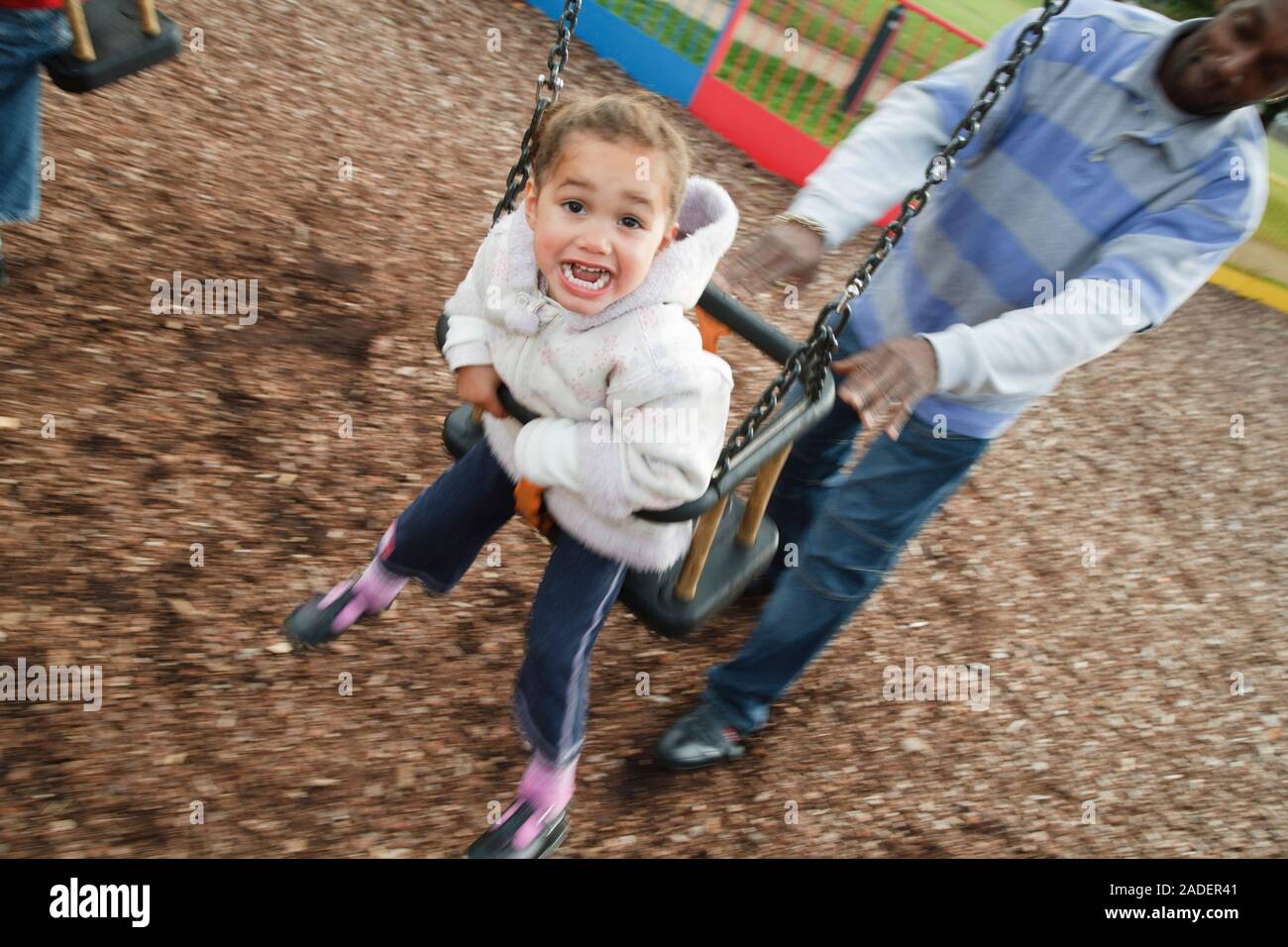 Man pushing girl on a swing Stock Photo - Alamy