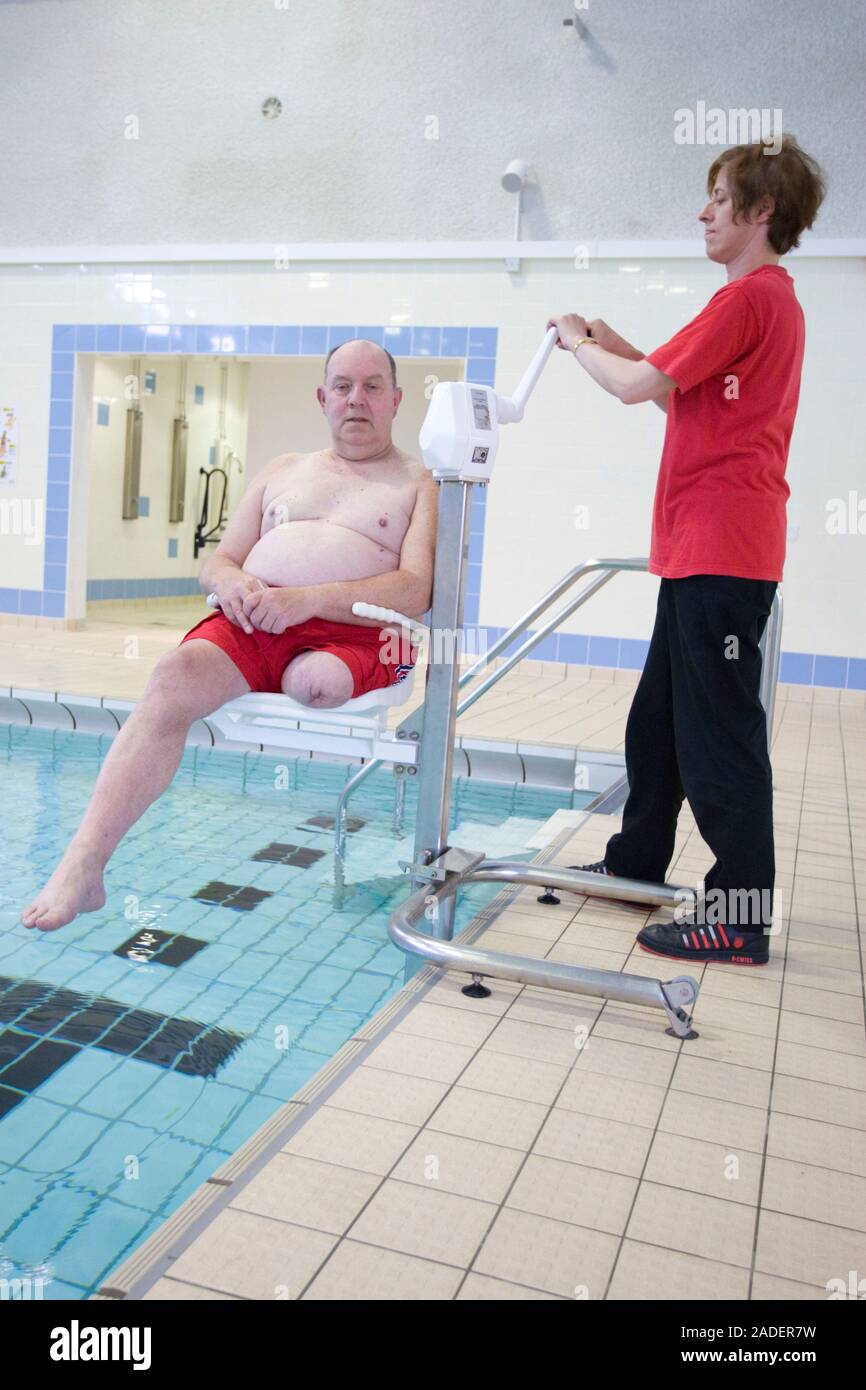 Disabled man, with the assistance of a member of staff, being lowered ...