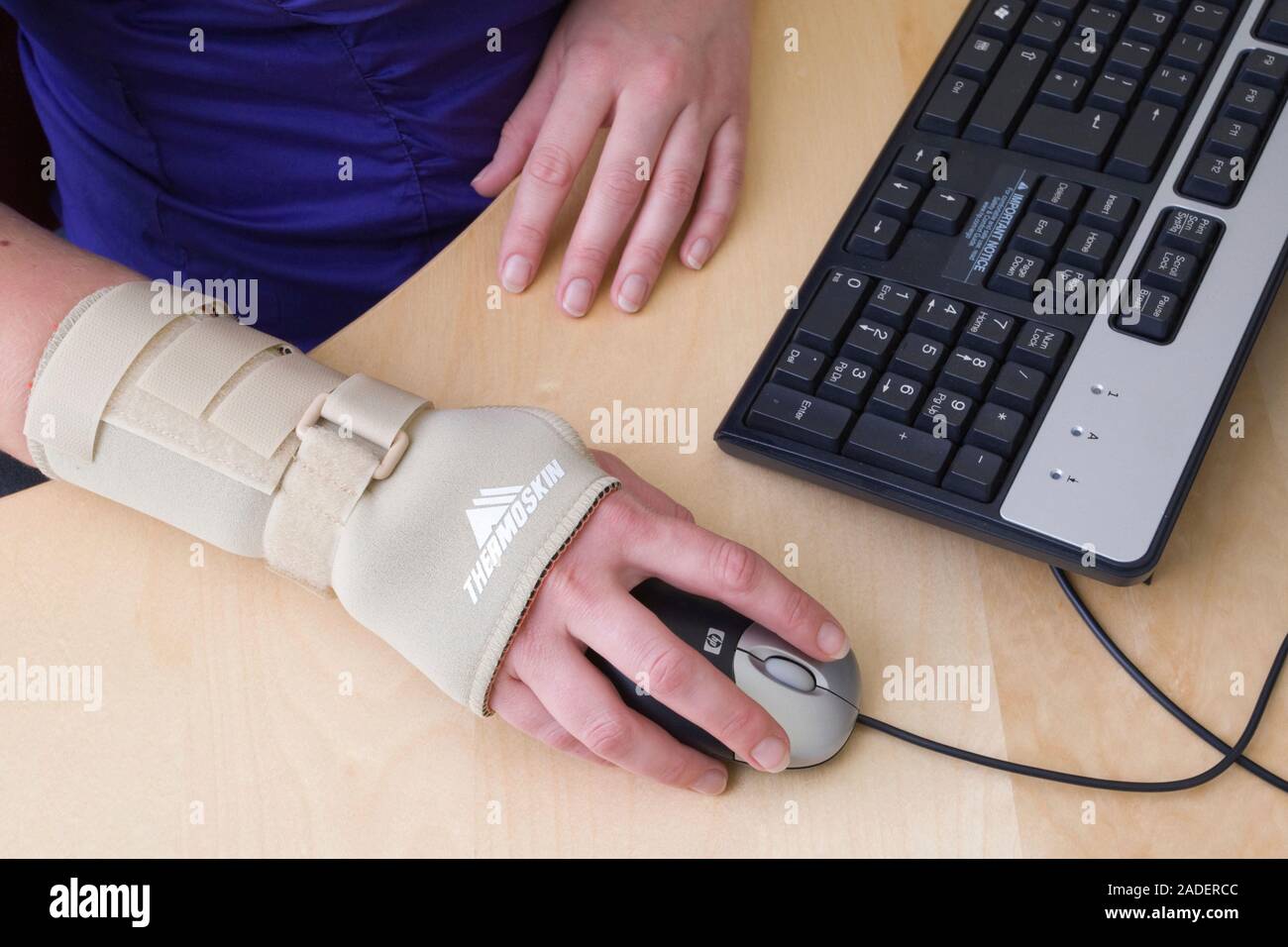 Office worker using a computer mouse whilst wearing an elasticated ...