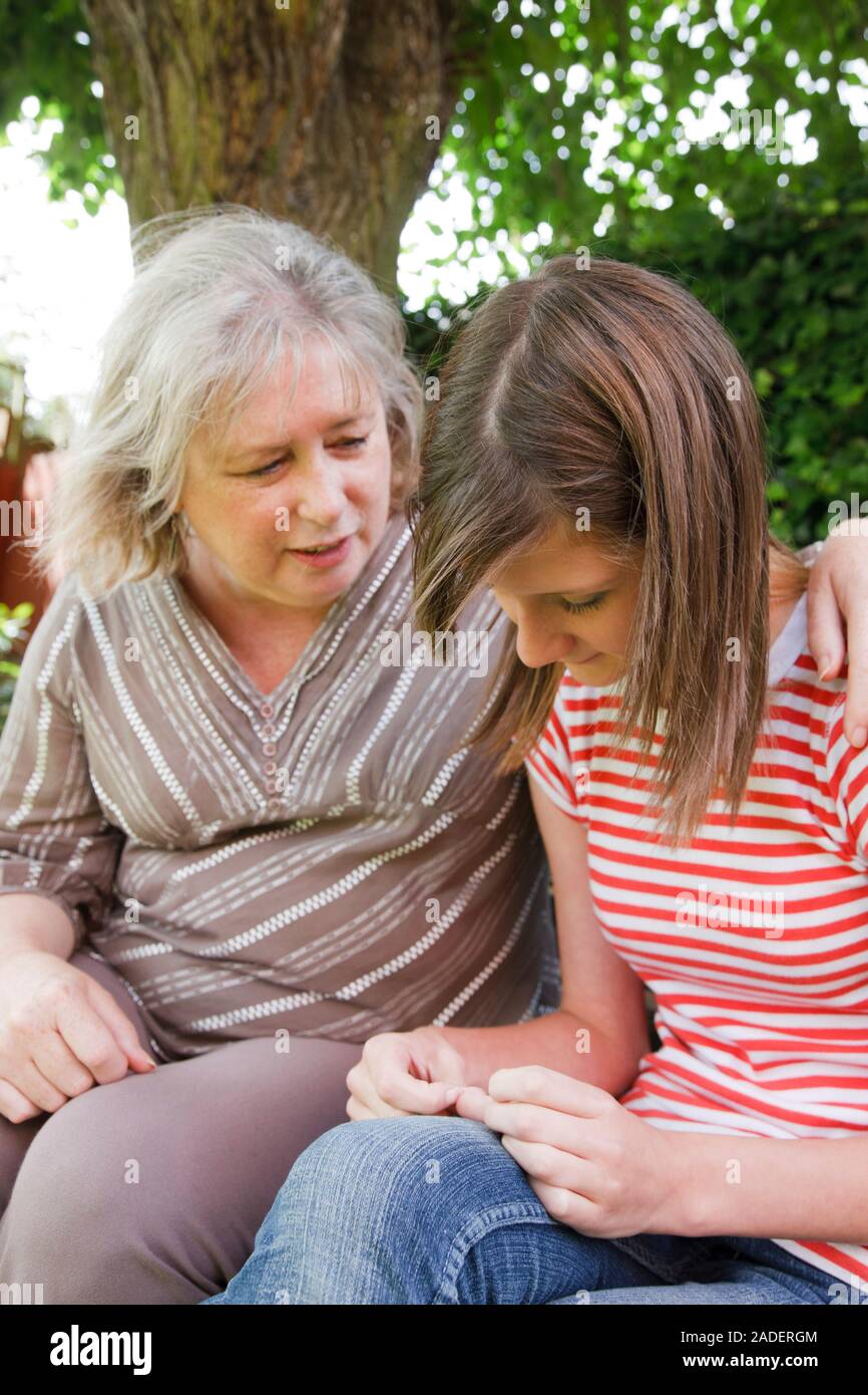 Woman and teenage girl talking on bench Stock Photo - Alamy