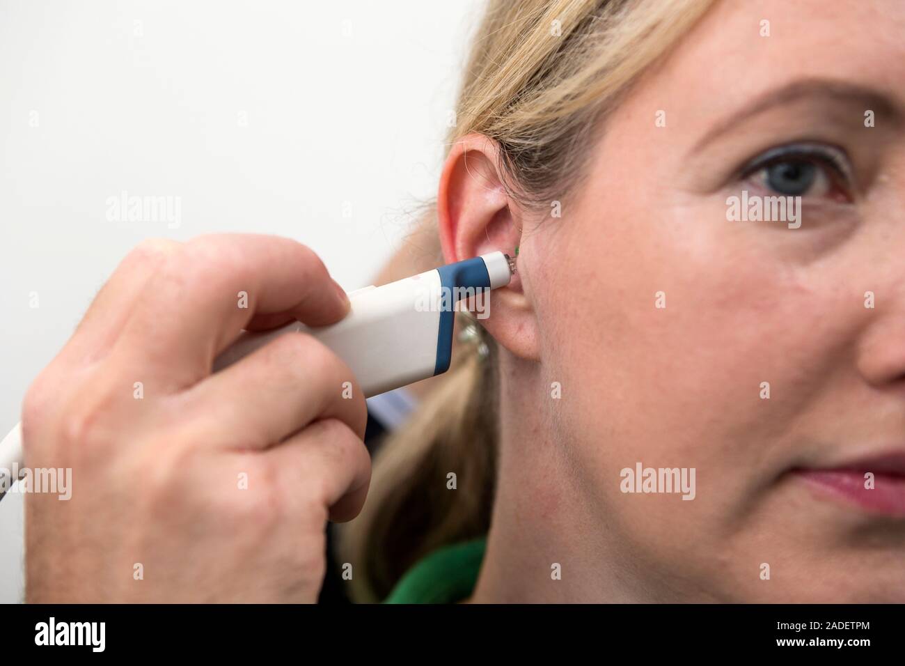 Audiologist carrying out a tympanometry assessment using a handheld ...