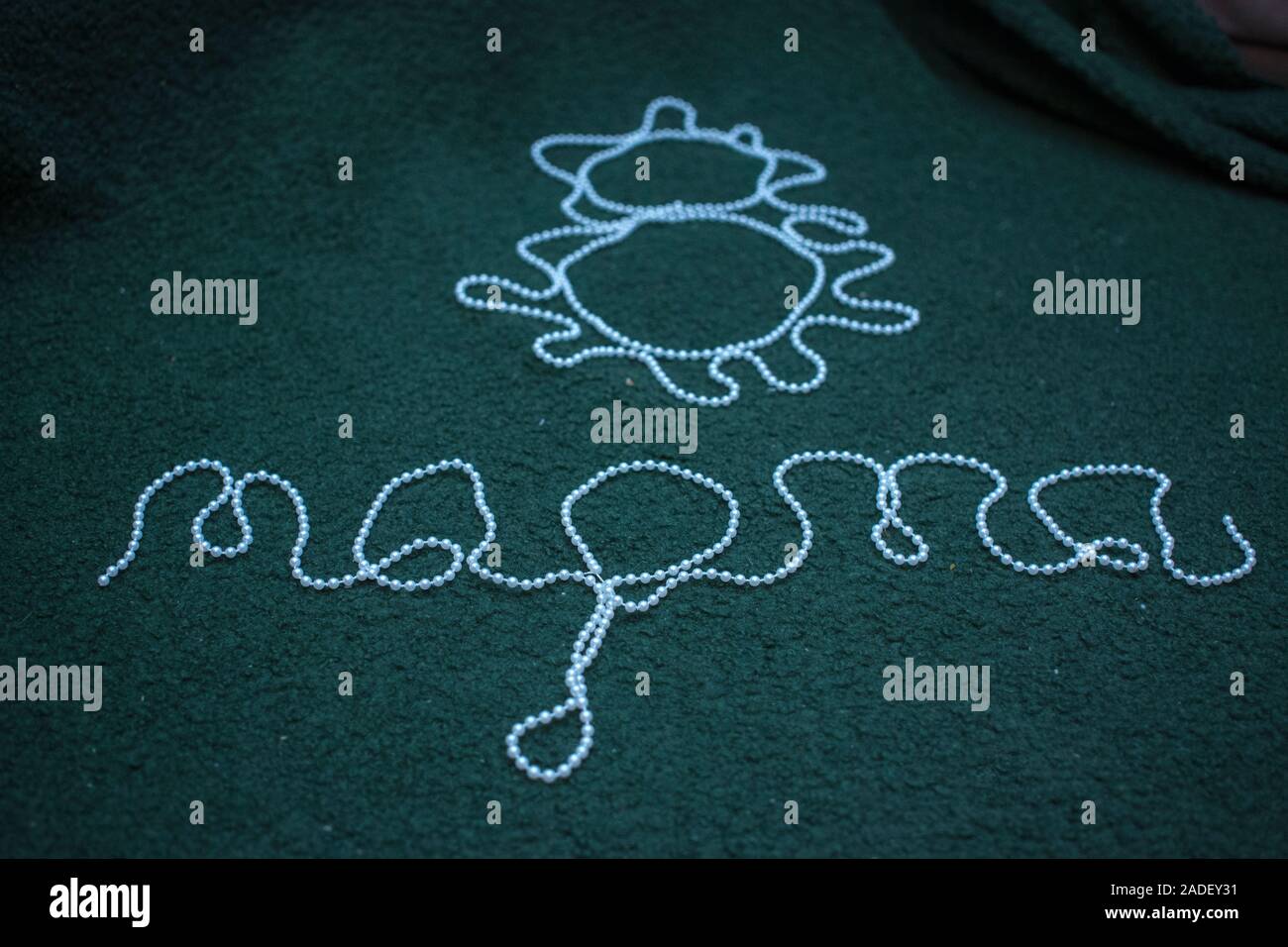 8 March symbol. Figure of eight made of white beads against green ...