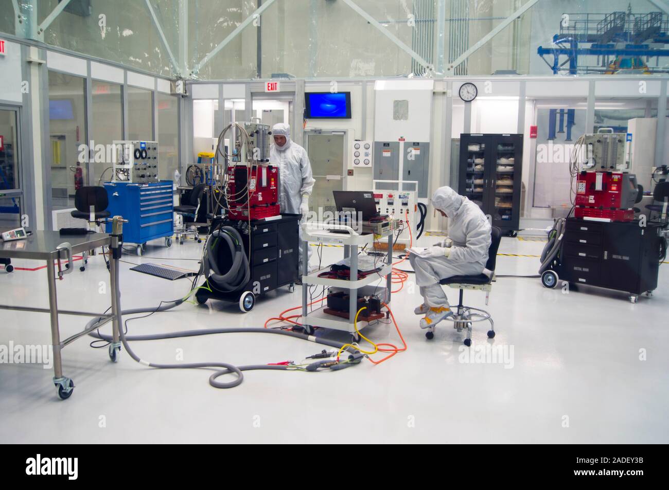 Two engineers working inside a large cleanroom tent inside a spacecraft ...