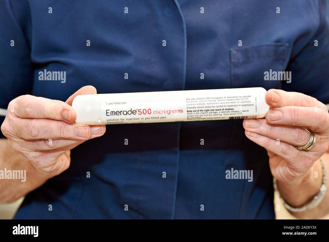 Adrenaline auto-injector pen. Close-up of a medical worker holding an ...