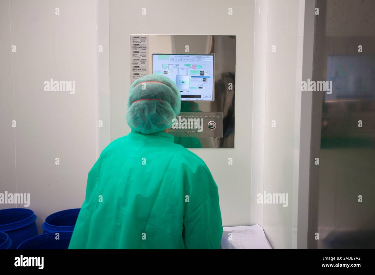Pharmaceutical drug production. Worker at a control panel in a drugs ...